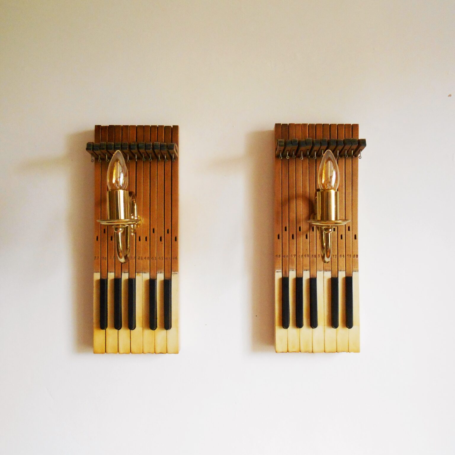 A pair of repurposed wall lamps with antique piano keys ...